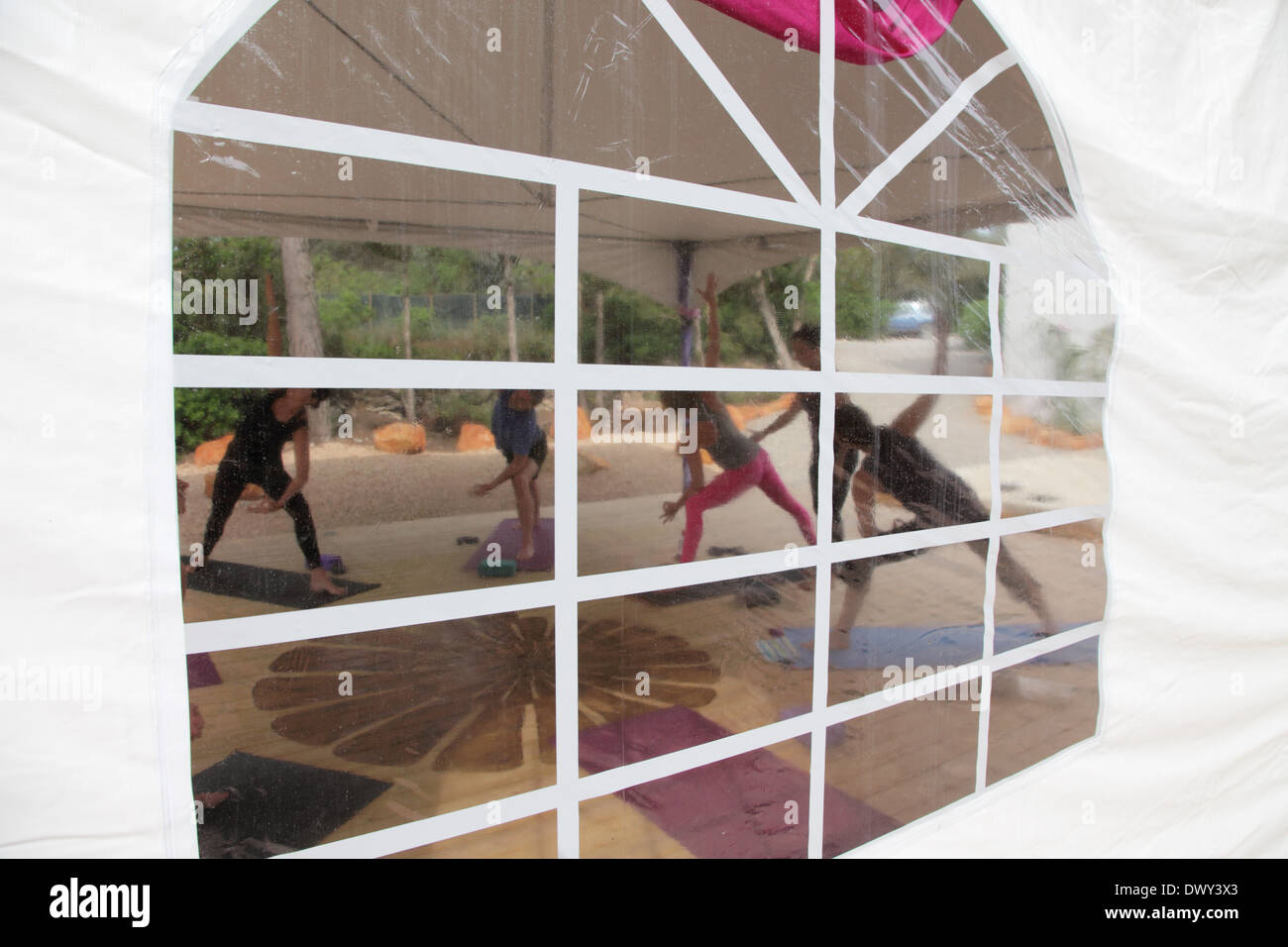 Yoga practice through window of marquee Stock Photo - Alamy