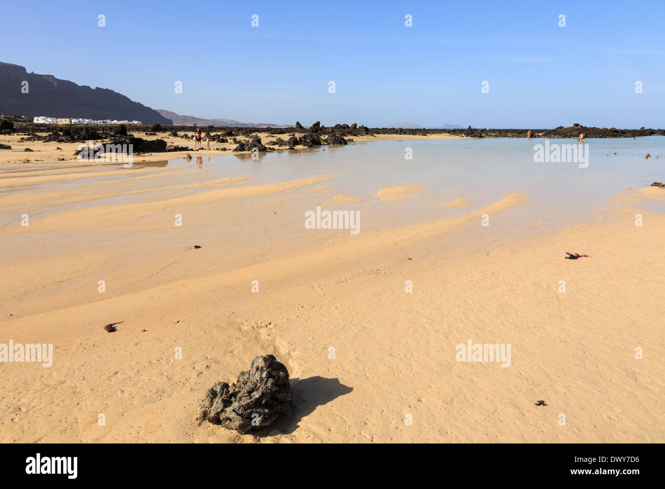 North coast white sand beach with people bathing in shallow tidal pools ...