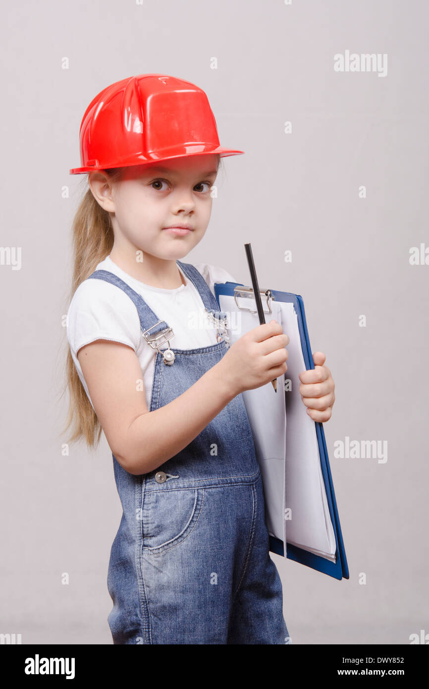 Girl engineer is a helmet folder and pencil Stock Photo - Alamy