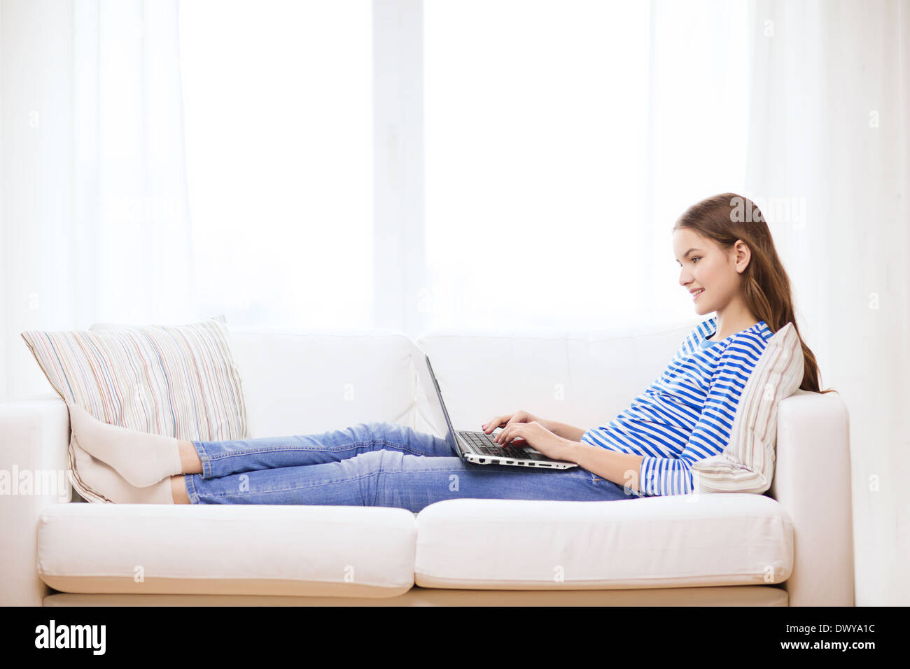 smiling teenage girl with laptop computer at home Stock Photo - Alamy