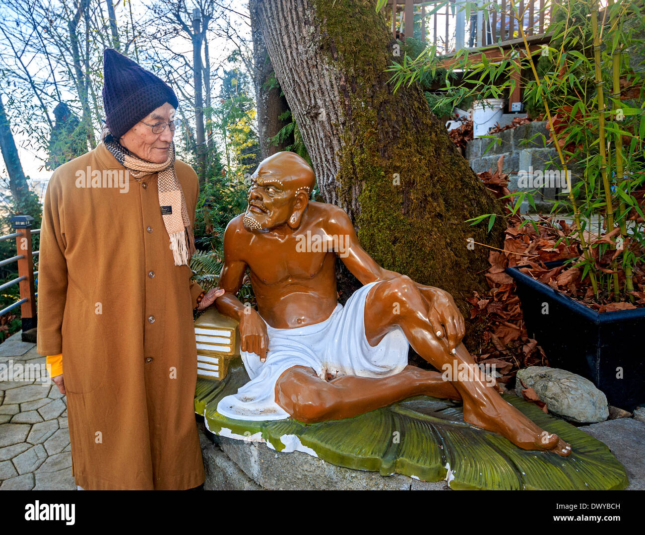 Buddhist monk with statue of Vanavasa, one of the 18 arahants ...