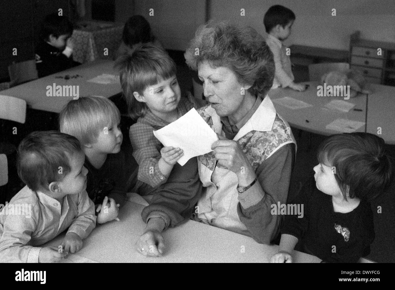 Berlin, GDR, child shows his kindergarten teacher a self- painted ...