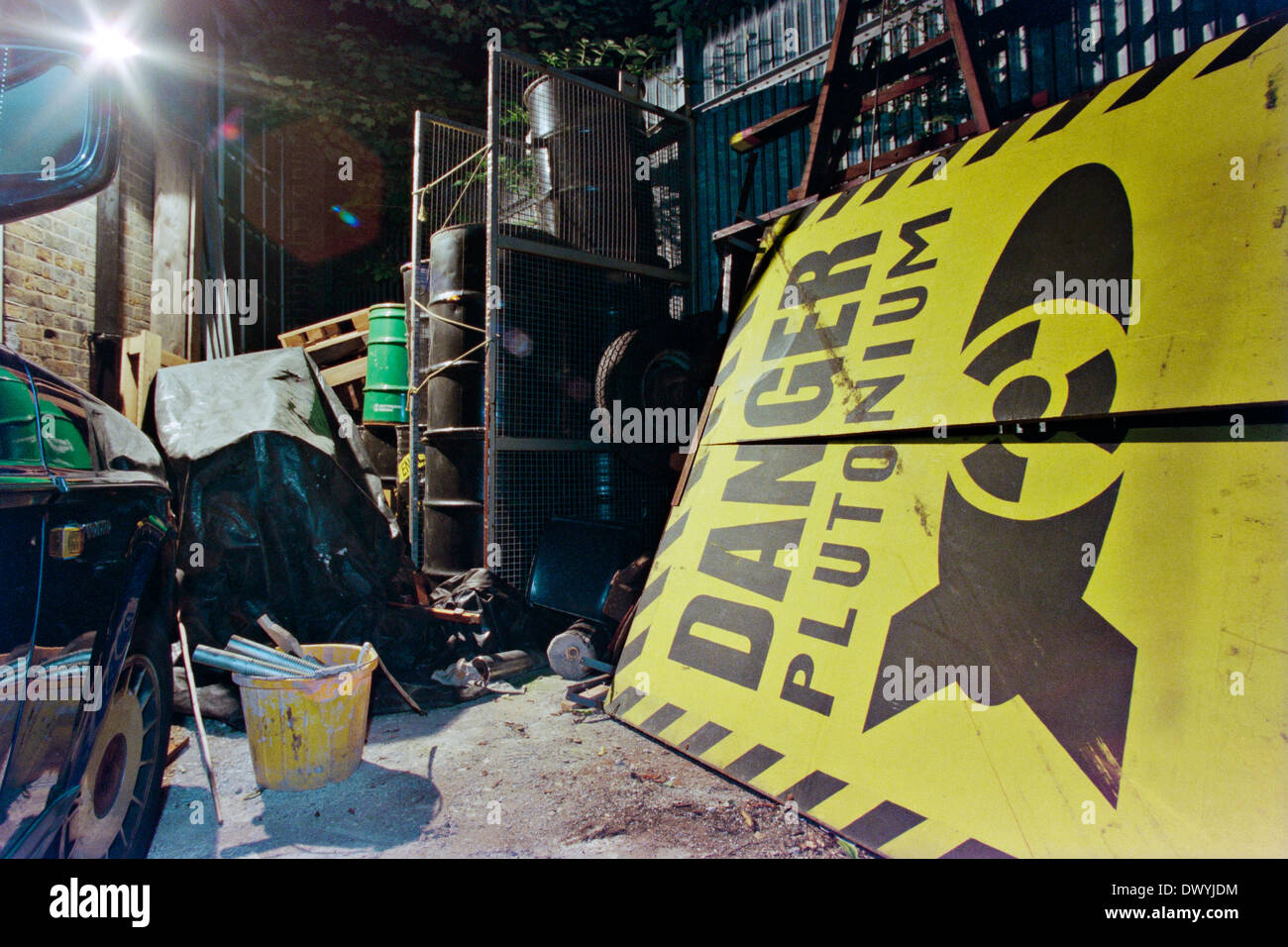 A " Danger Plutonium" warning sign and old oil drums in a backyard ...
