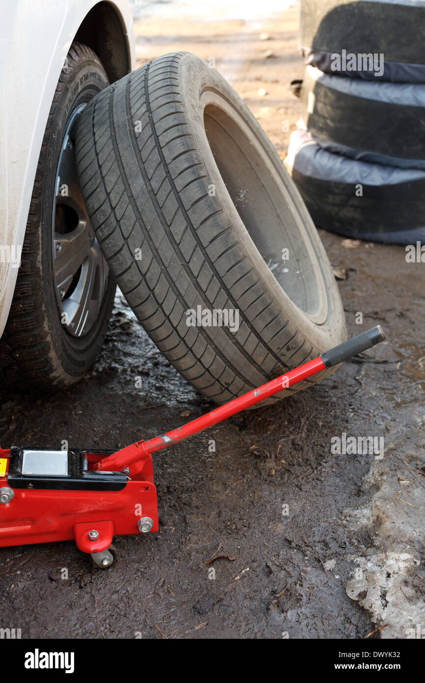 seasonal replacement of tires with jack outdoors - car tire fitting ...
