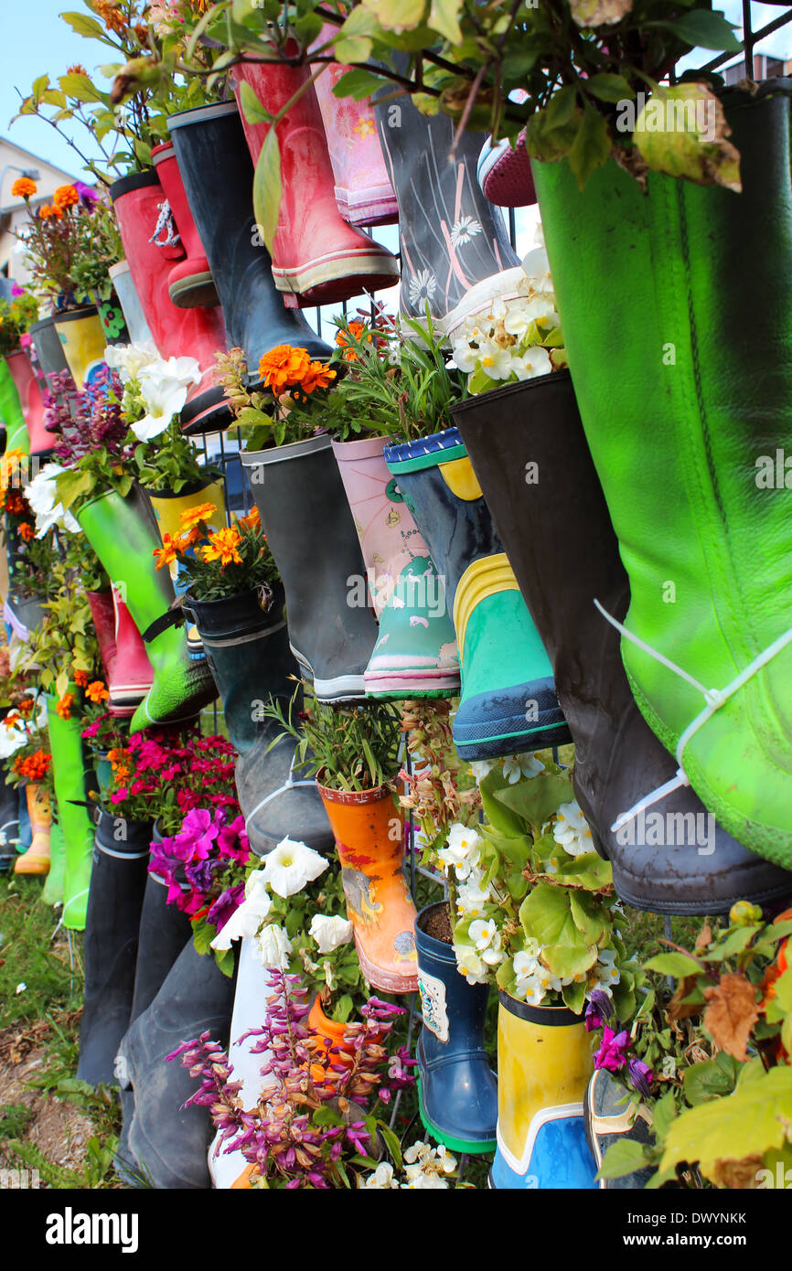 Colorful rubber boots with flowers inside strapped to a fence Stock ...