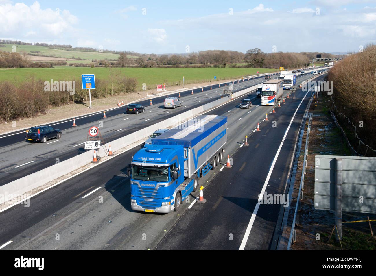 Traffic passing a coned off area on the M25 motorway in Surrey, UK ...
