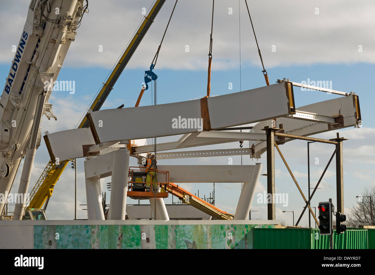 Crane lifting a section of a footbridge under construction at the ...