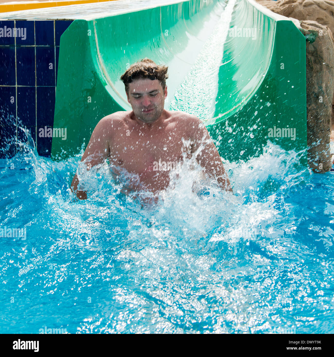 Young man having very good fun at waterslides Stock Photo - Alamy