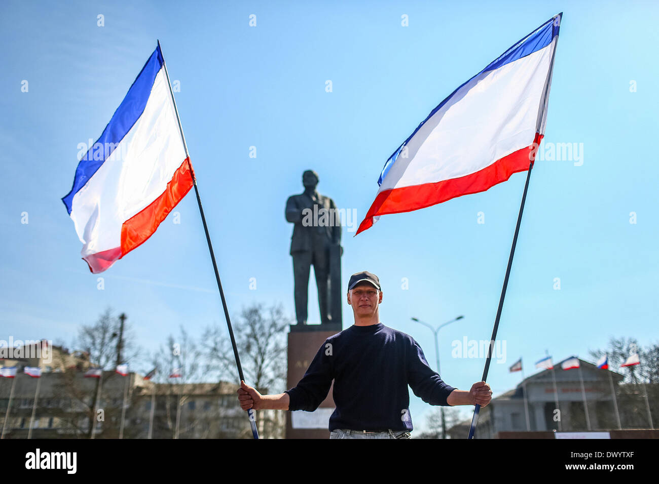 A man holds Crimean flags in front of the Lenin memorial at Lenin ...