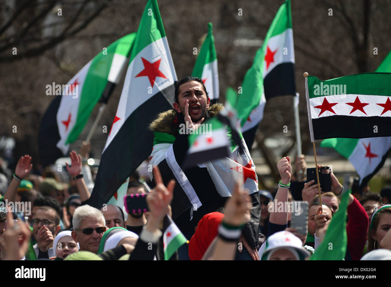 Washington DC, USA . 15th Mar, 2014. Activists waive the Syrian and ...