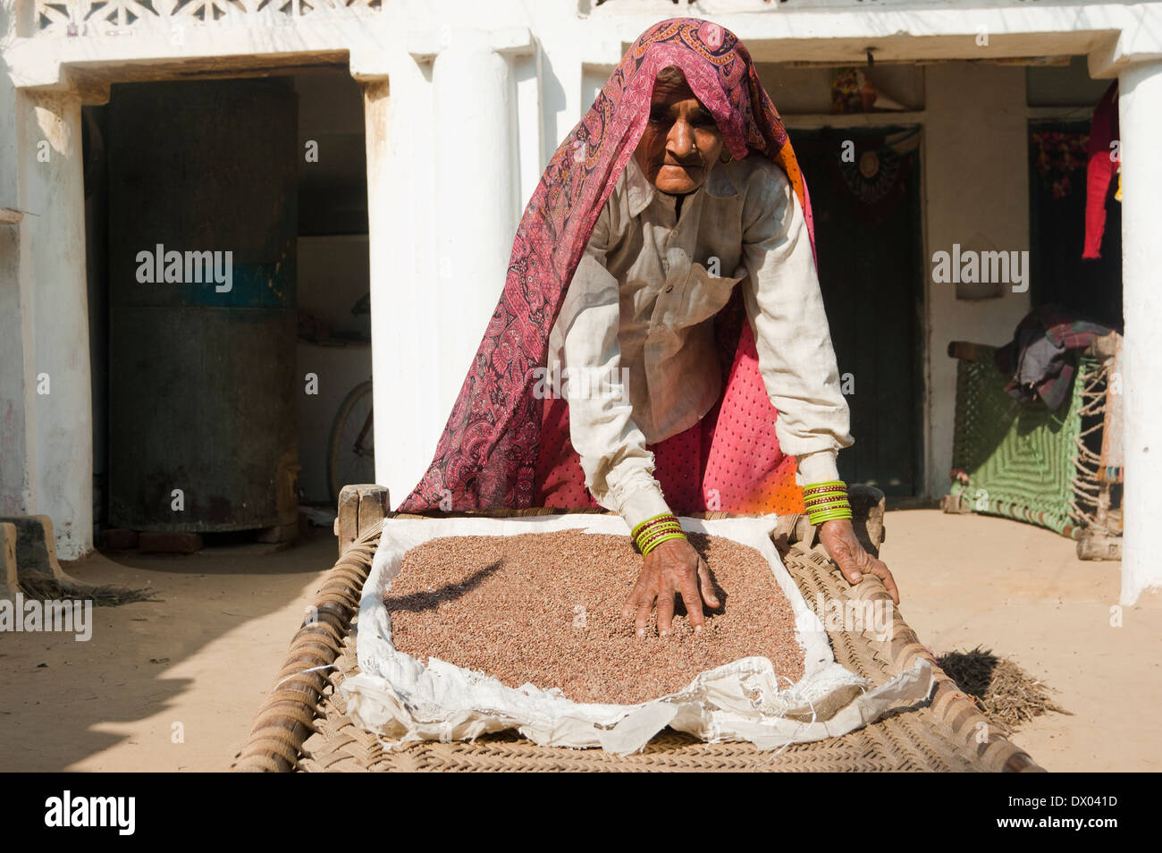 Old woman drying grains hi-res stock photography and images - Alamy
