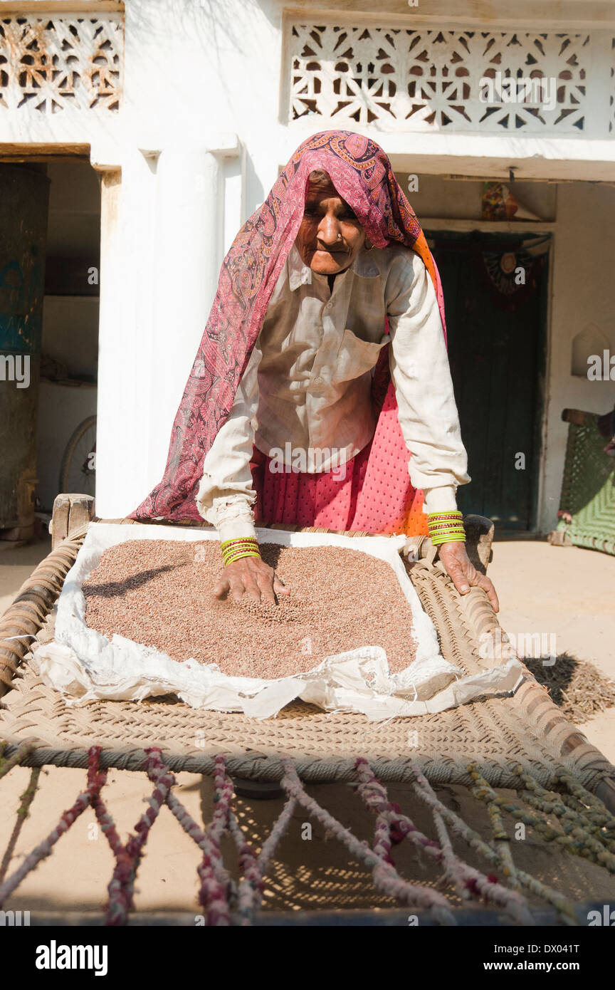 Old woman drying grains hi-res stock photography and images - Alamy