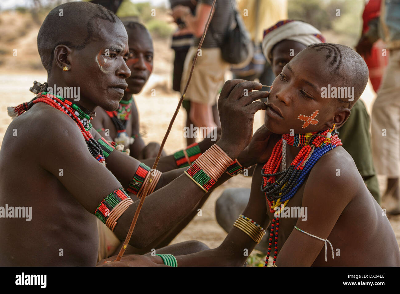 Young Hamer men painting their faces at a bull jumping ceremony in the ...
