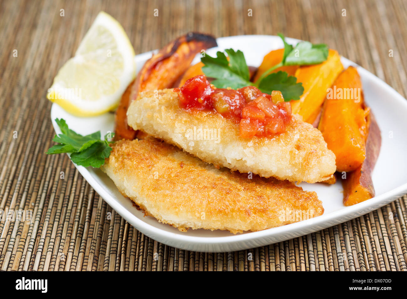Closeup horizontal of golden crisp fried cod fish with salsa sauce on ...