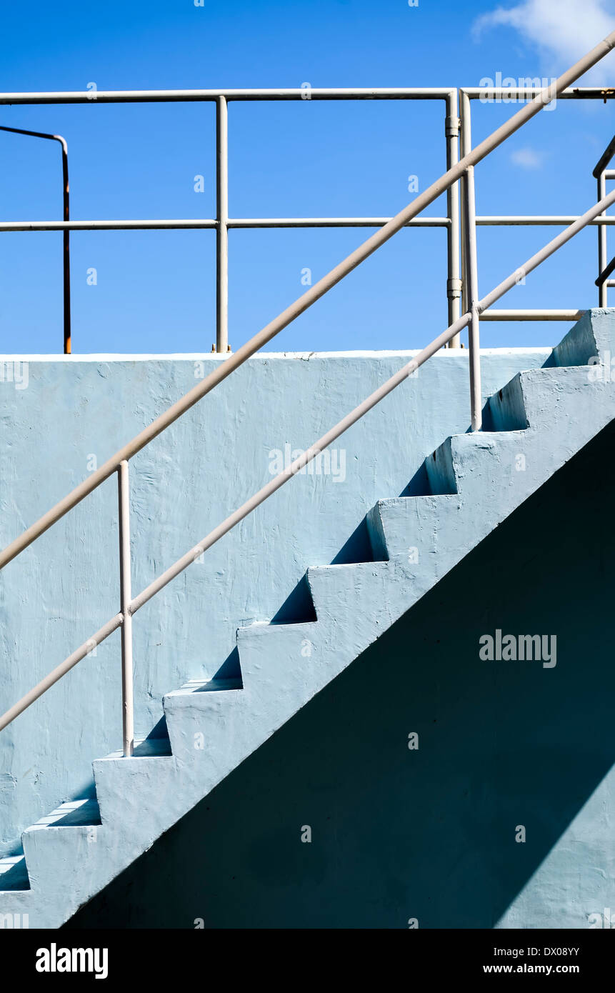Blue concrete stairs with galvanized railing pipes Stock Photo - Alamy