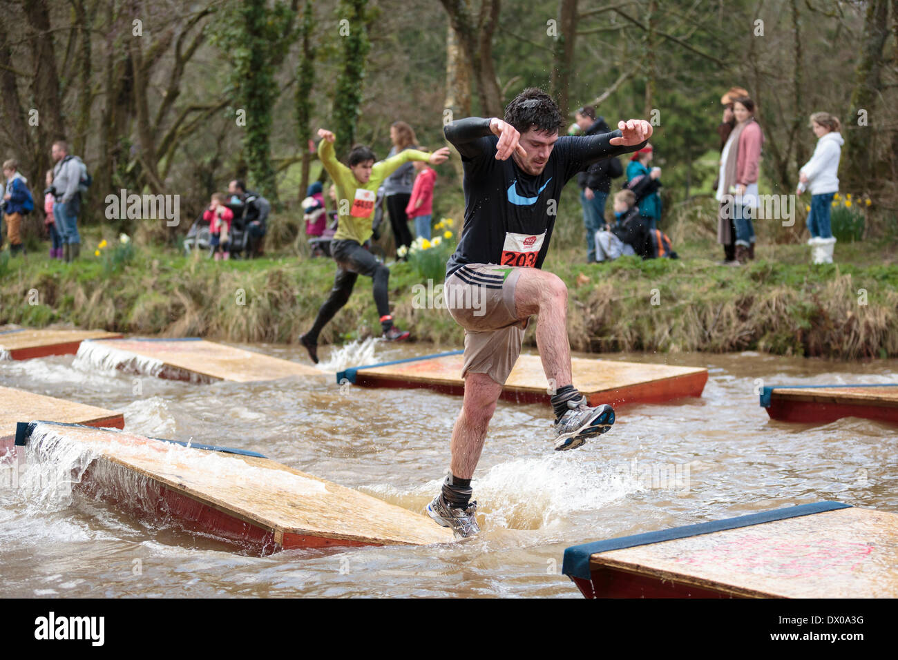 Exeter, Devon. March 15th 2014. A man leaps across floating stepping ...