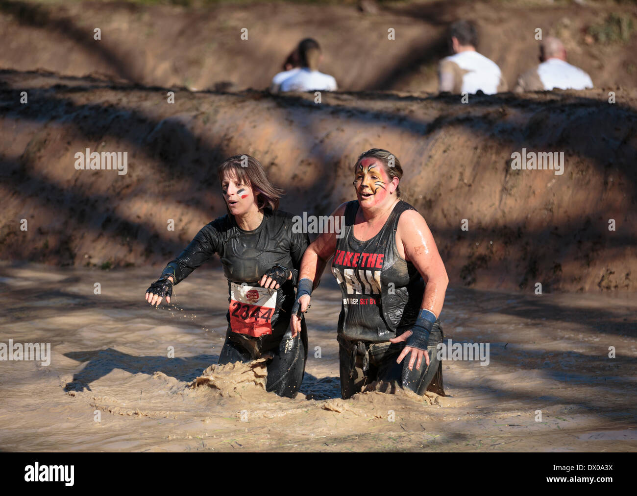 Exeter, Devon. March 15th 2014. Two women wade through muddy trenches ...