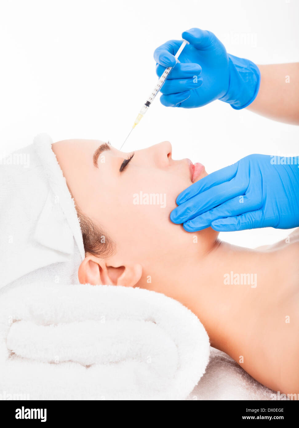 Beautiful woman gets injection in her face over white background Stock ...