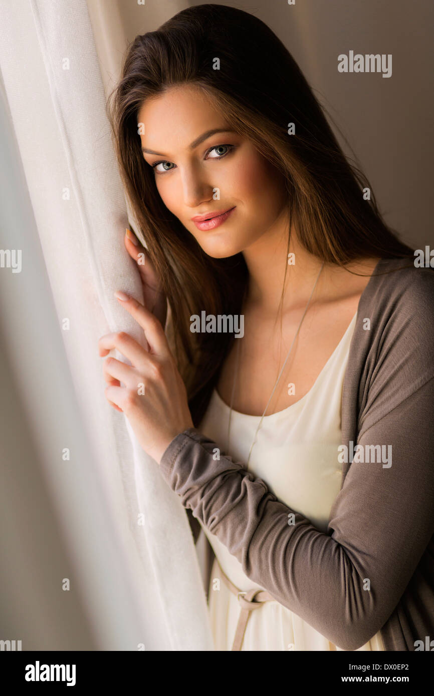 Pretty young woman by the window Stock Photo - Alamy