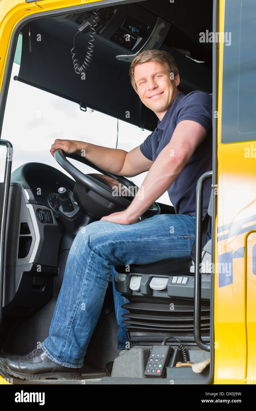 Logistics - proud driver or forwarder in drivers cap of truck and ...