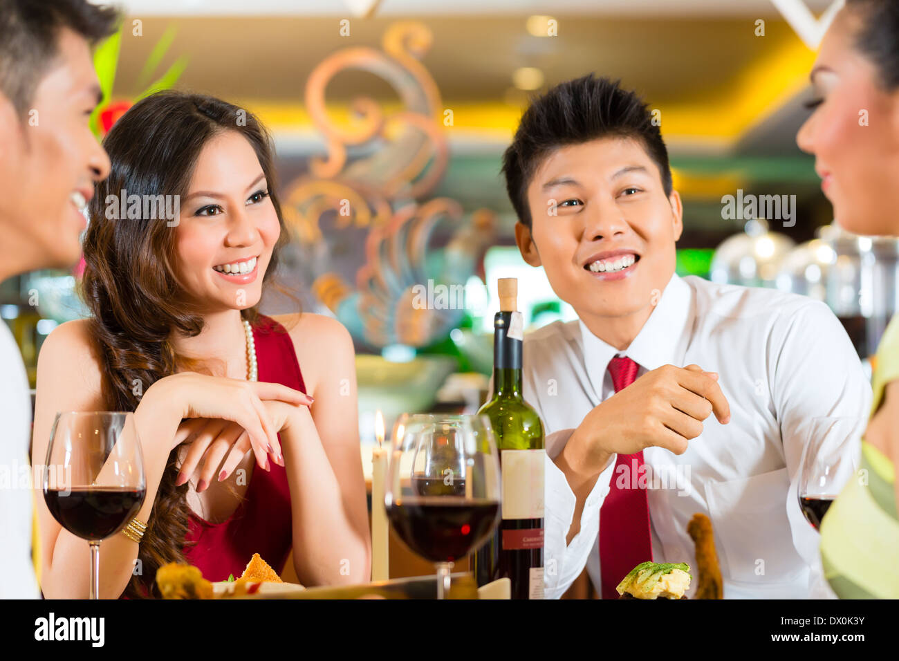 Four Asian Chinese business people having dinner in elegant club ...