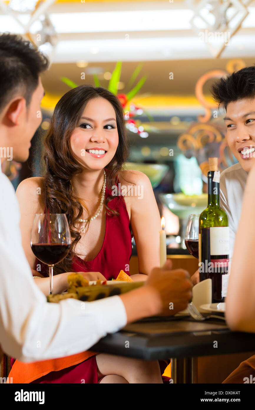 Four Asian Chinese business people having dinner in elegant club ...