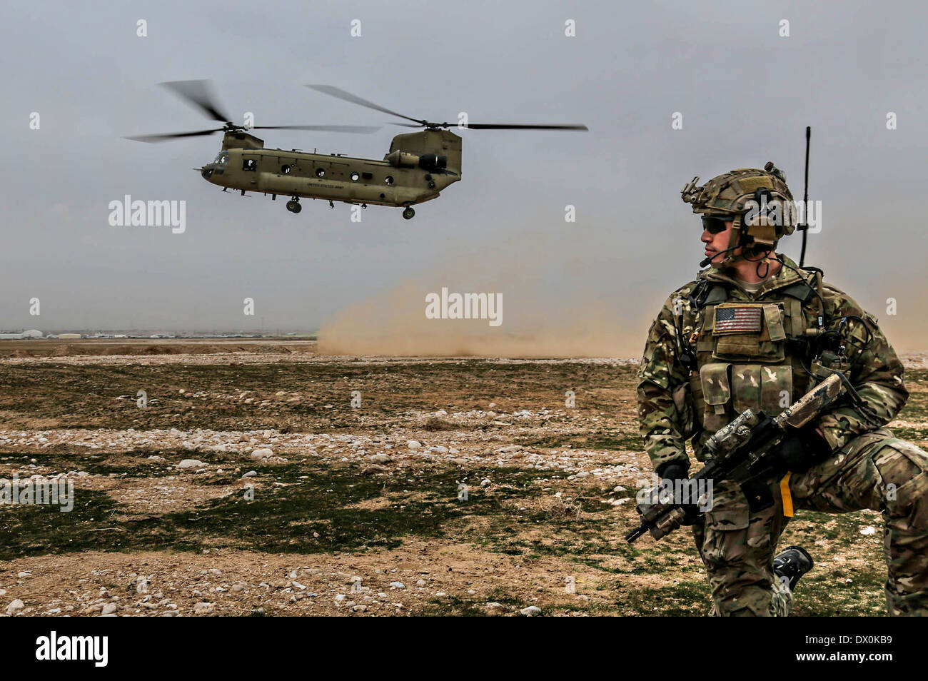 A US army soldier waits for a CH-47 Chinook helicopter to land ...