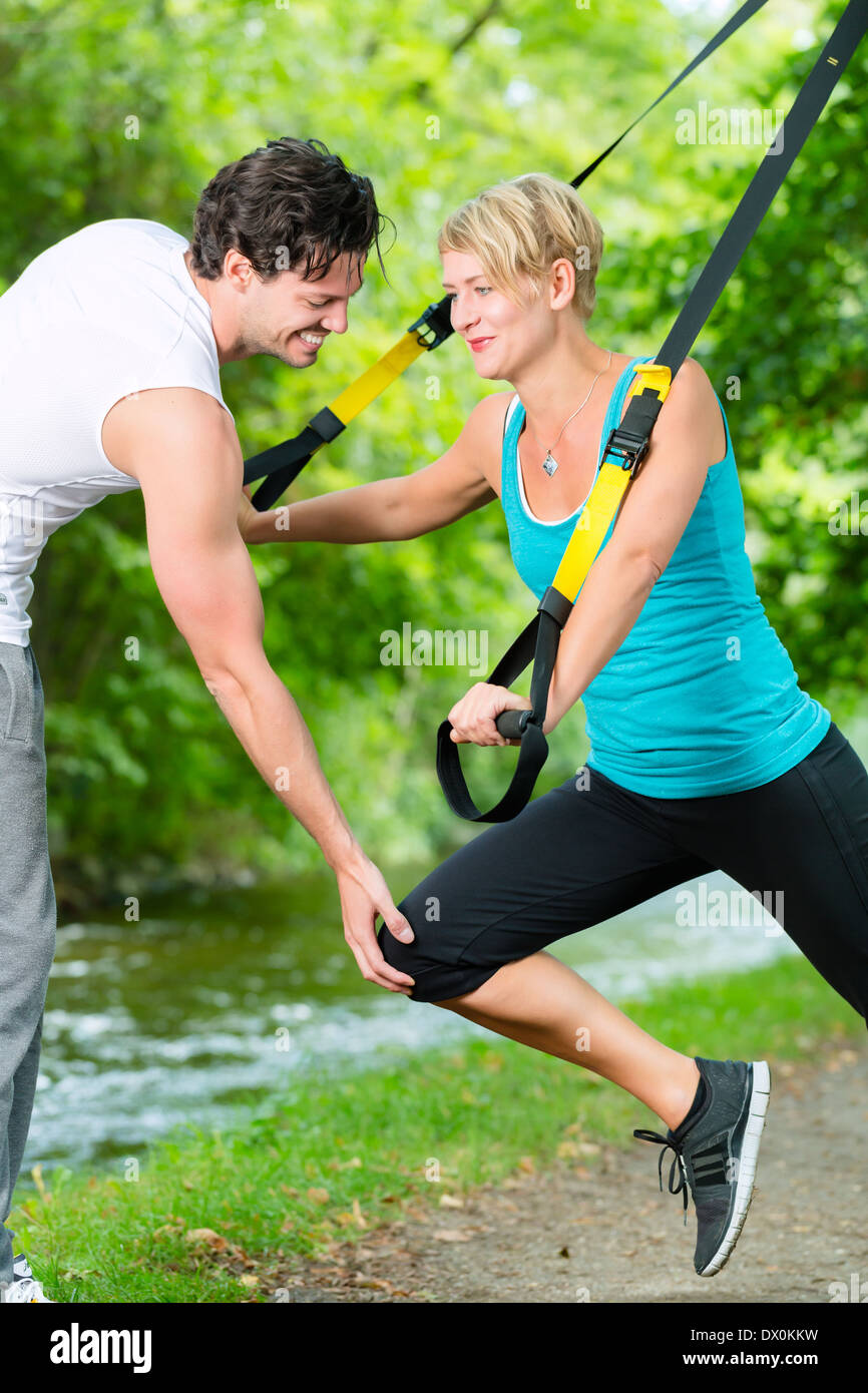Fitness woman exercising with suspension trainer and personal sport ...