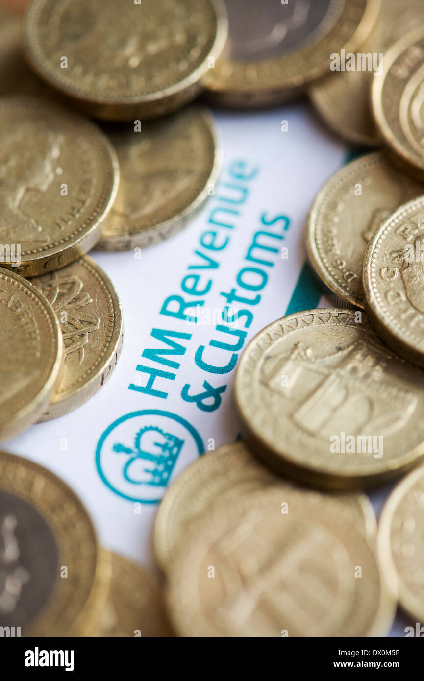 English coins around HM revenue and customs form Stock Photo - Alamy