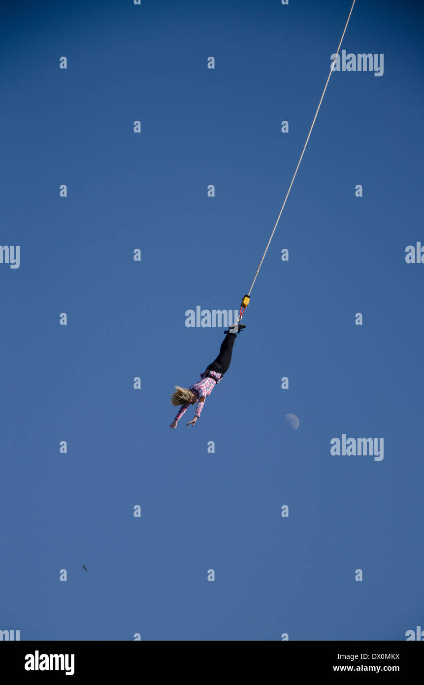Woman during bunji jump in blue sky with moon Stock Photo - Alamy