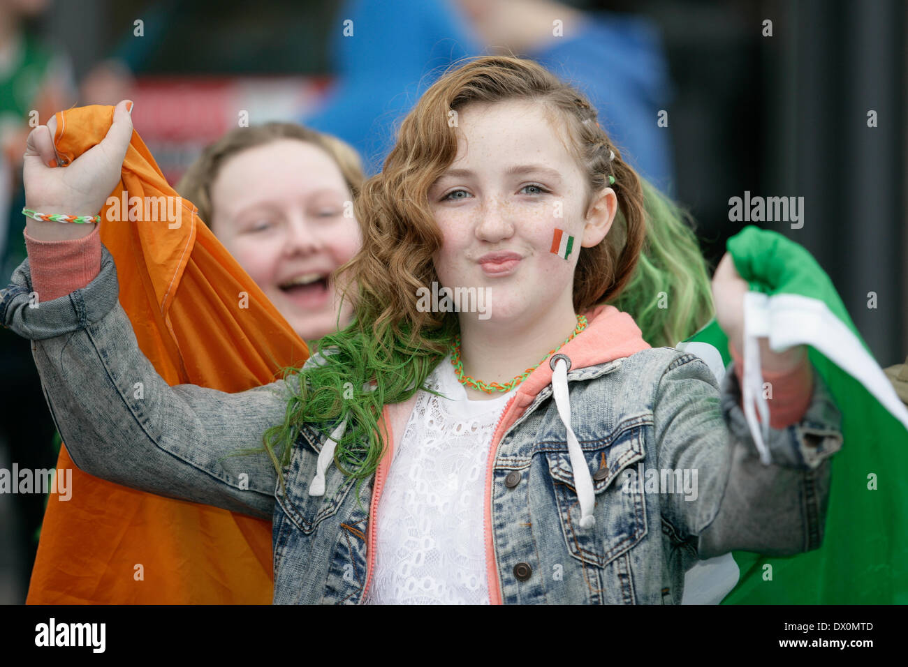 Belfast UK, 16th March, 2014. A young girl holds the Irish Tri-Colour ...