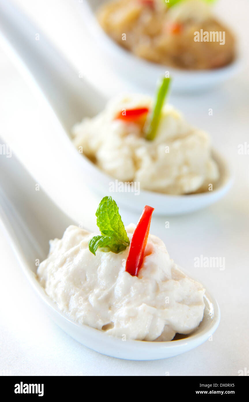 assortment of dips served in porcelain spoons as a finger food(garlic ...