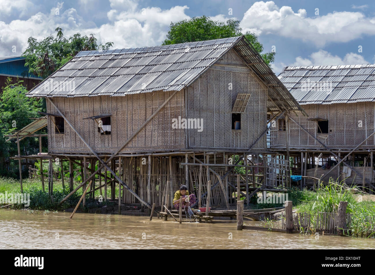 Lakeside house with woman washing clothes, Inle Lake, Myanmar Stock ...