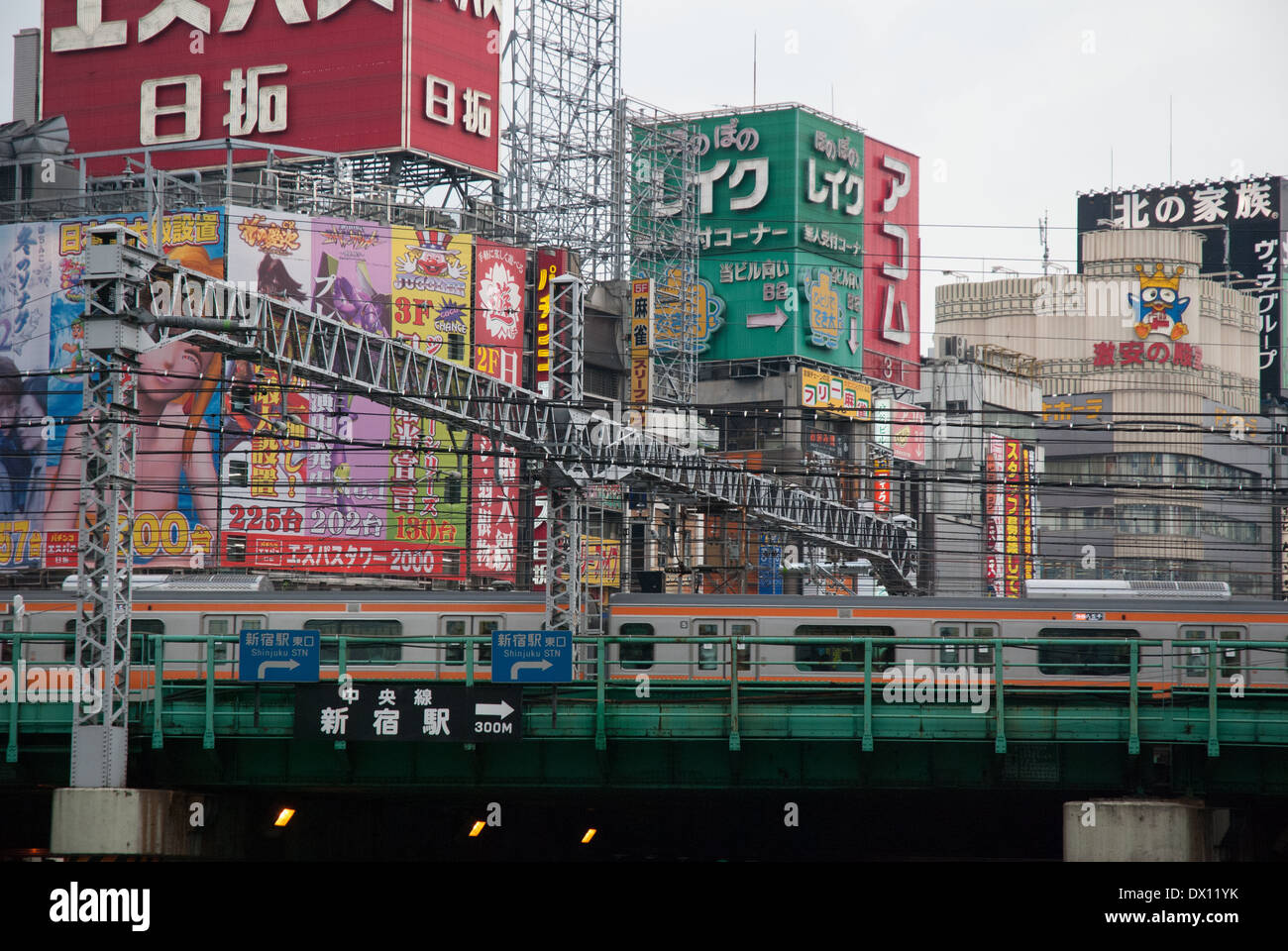 Train passing by in front of electric wires and buildings in Shinjuku ...