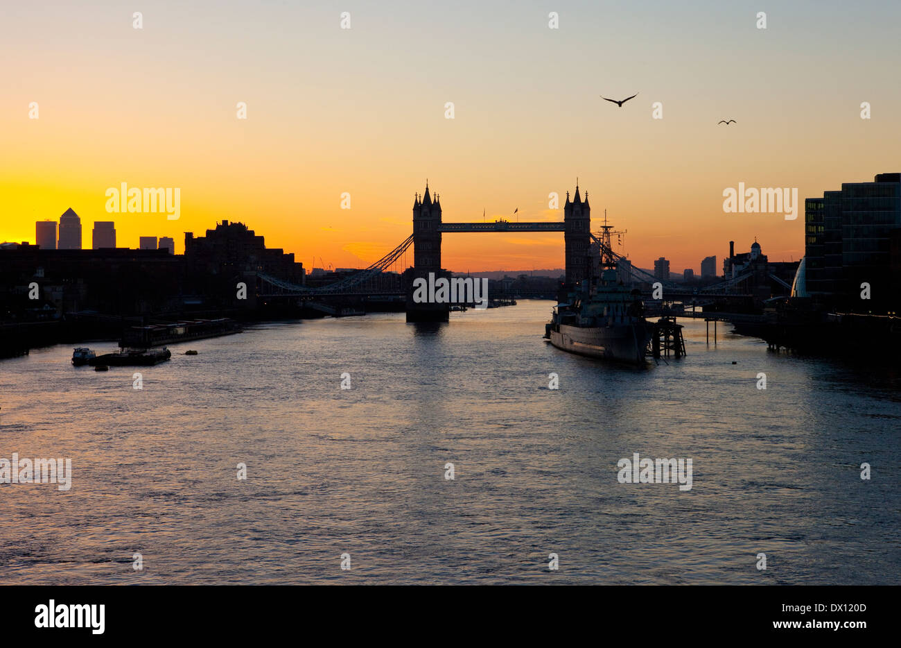 The beautiful sunrise behind Tower Bridge in London. HMS Belfast, City Hall and the skyscrapers ...