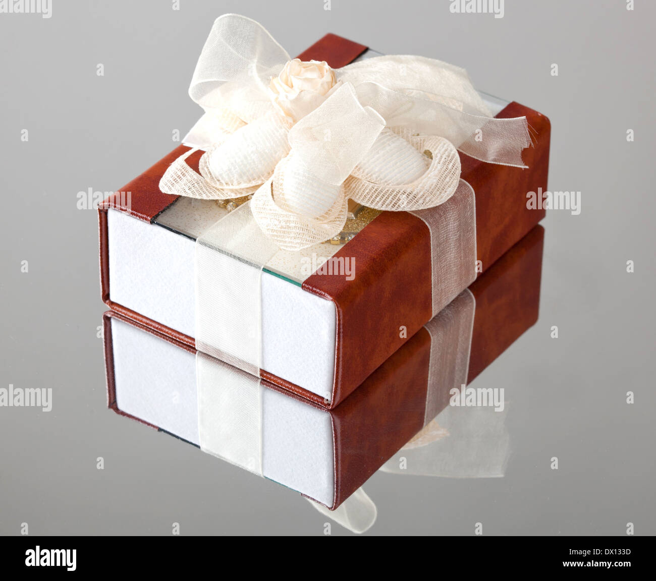 The gift box with a brown cover is wrapped up by a beige tape with a ...