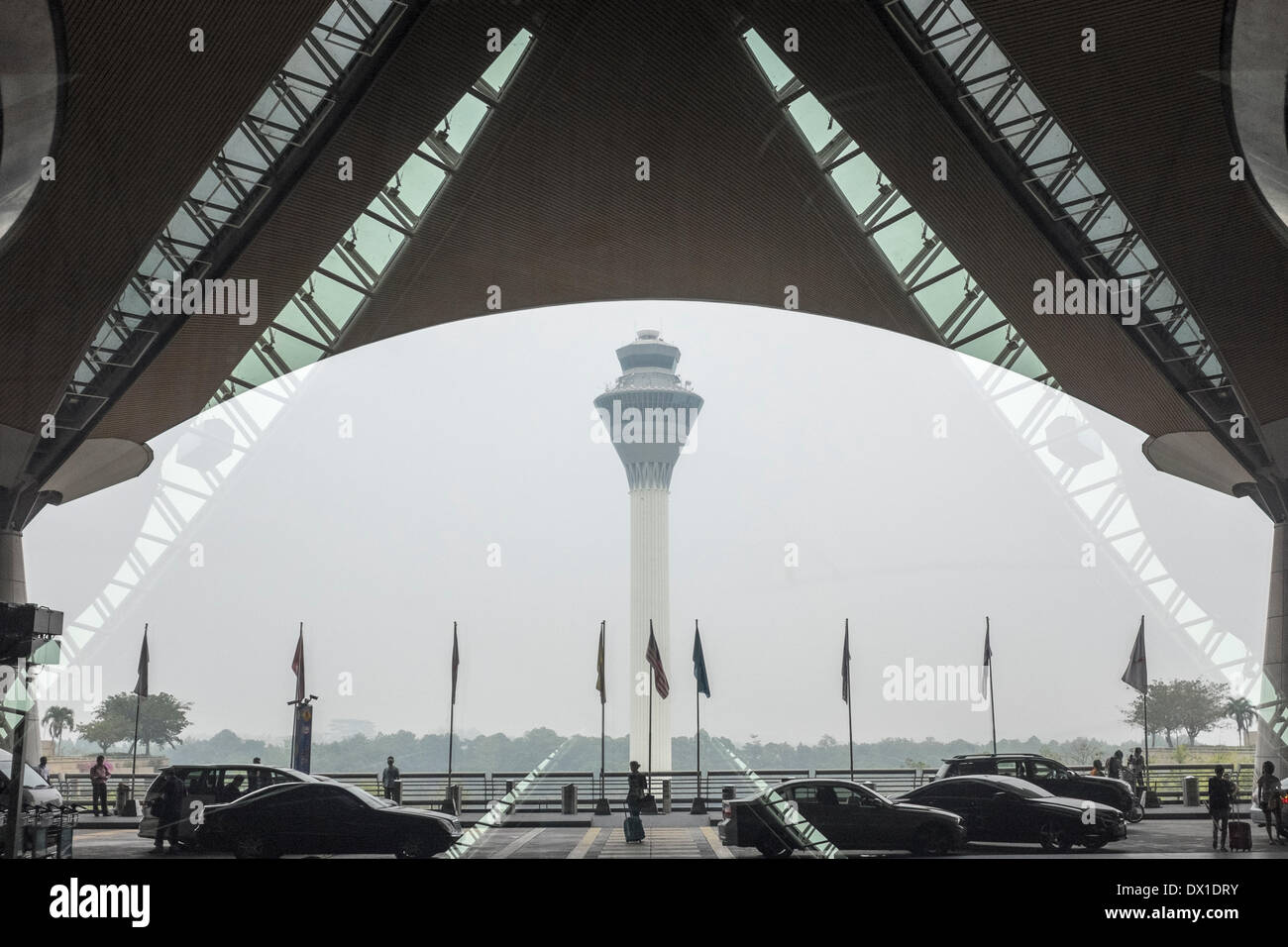 The airport control tower is reflected in the windows of the departures ...