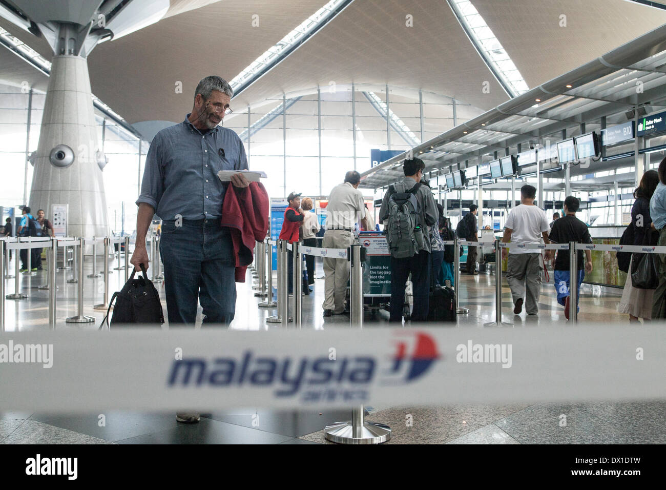 A passenger arrives at the check-in area for Malaysian Airline System ...