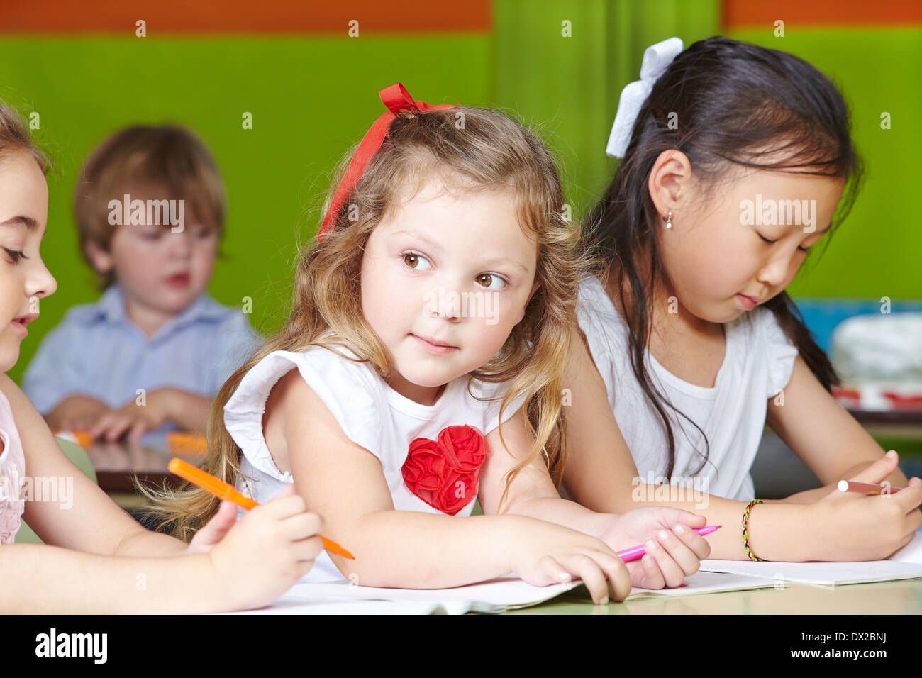 Different children drawing with pens and coloring book in a ...