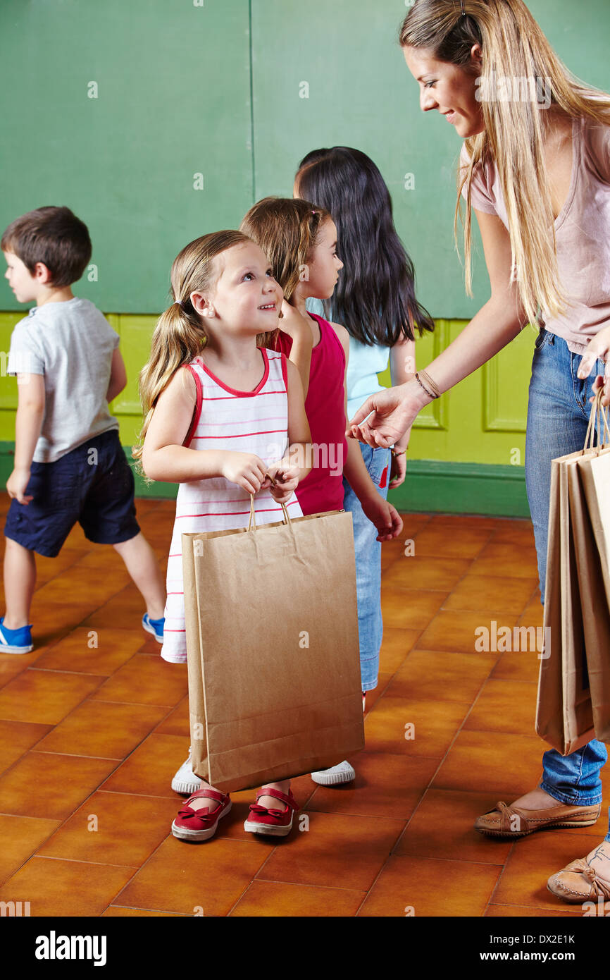 Kindergarten teacher giving bags with gifts to group of children Stock ...