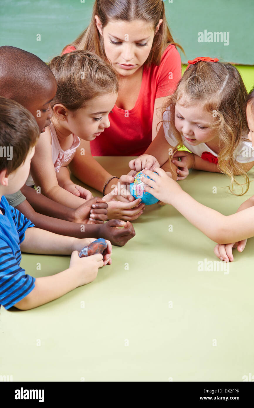 Kids learning geography in kindergarten with a little globe Stock Photo ...
