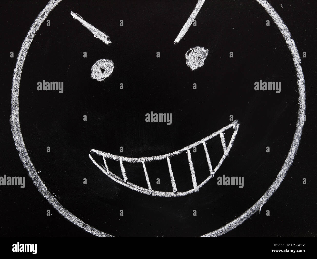 Draw evil face on a black billboard Stock Photo - Alamy