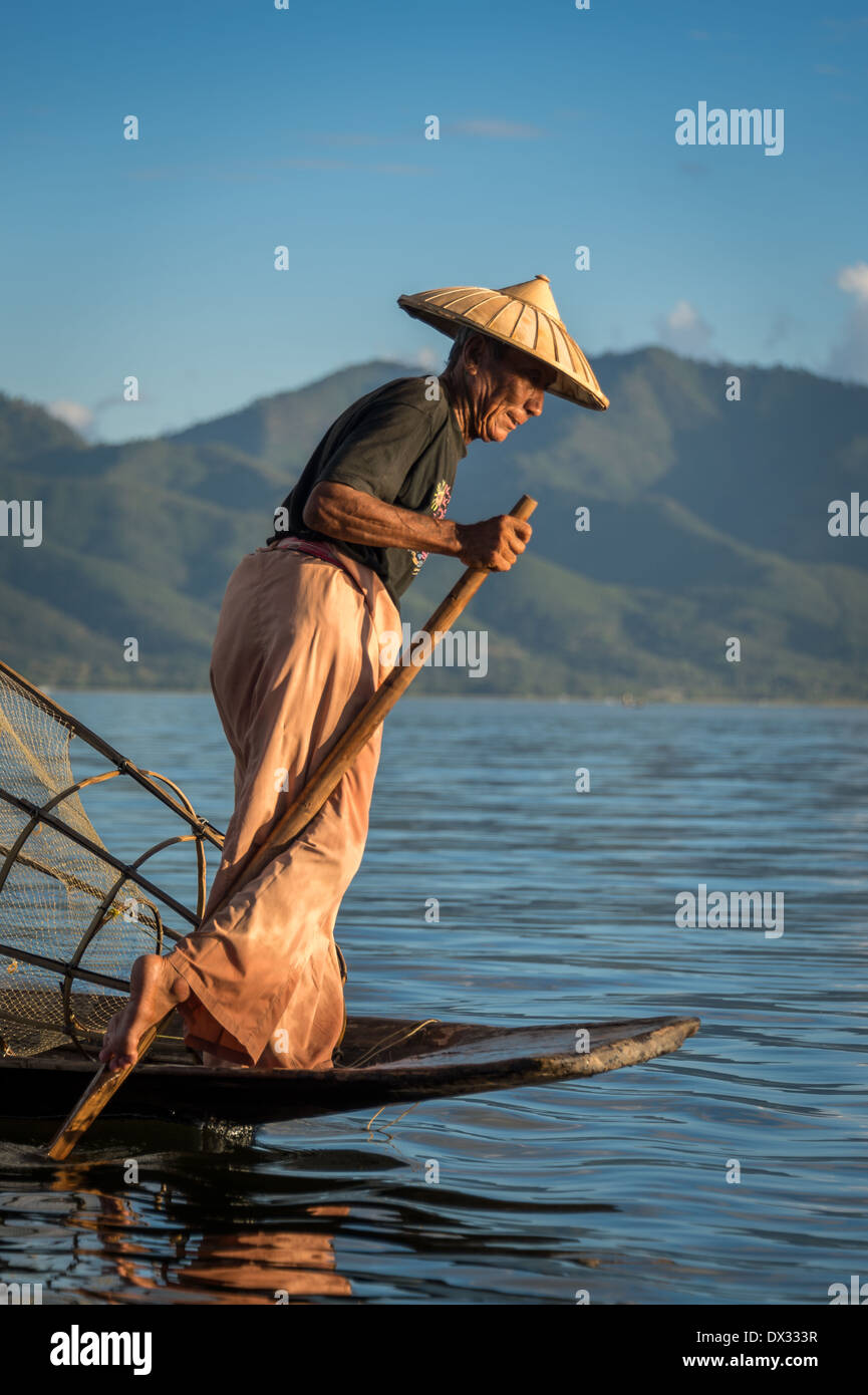 INLE LAKE, MYANMAR - CIRCA DECEMBER 2013: Fisherman rowing a typical ...