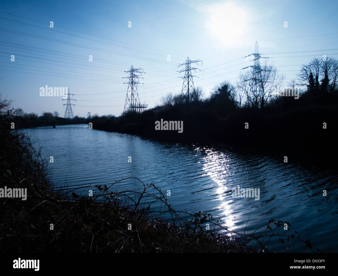 Row of electricity pylons and river, in UK Stock Photo - Alamy