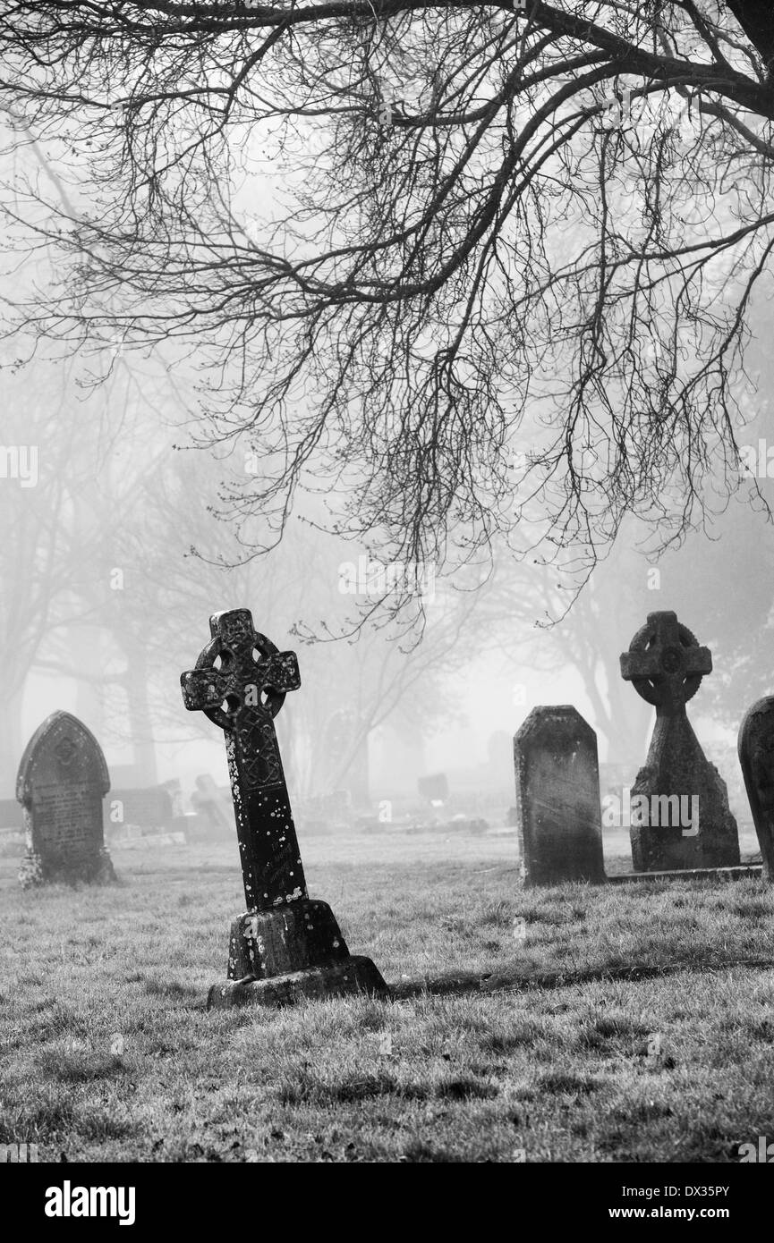 Cross Gravestone in the fog at Banbury Cemetery, Oxfordshire, England ...