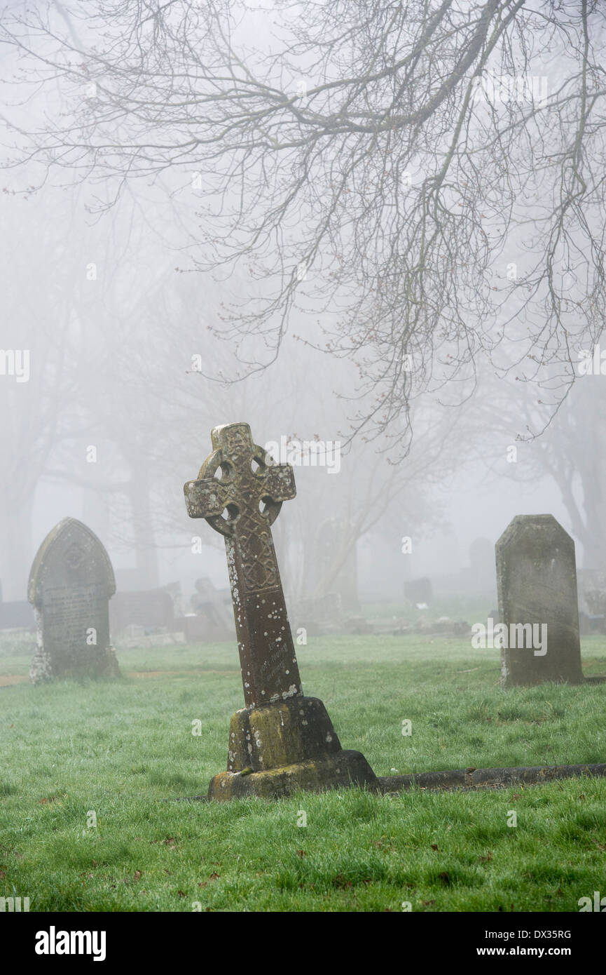 Cross Gravestone in the fog at Banbury Cemetery, Oxfordshire, England ...