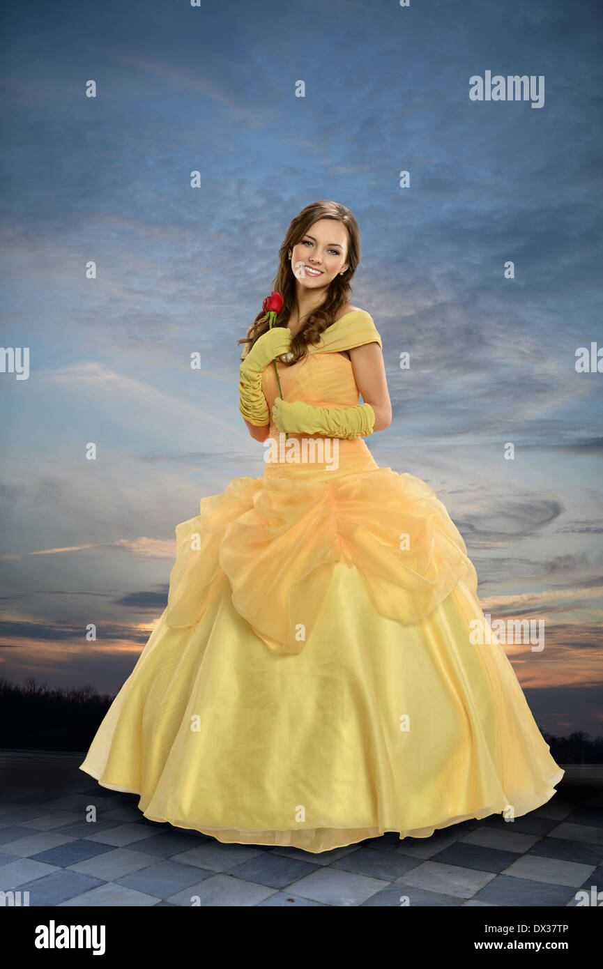 Beautiful young woman dressed in princess costume holding rose with ...