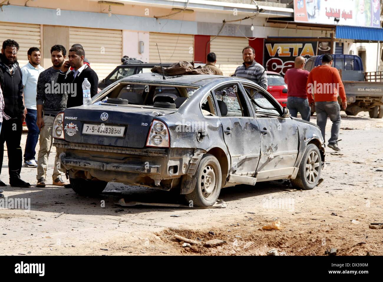 Benghazi, Libya. 17th Mar, 2014. People check a damaged car in Benghazi, Libya, March 17, 2014 ...