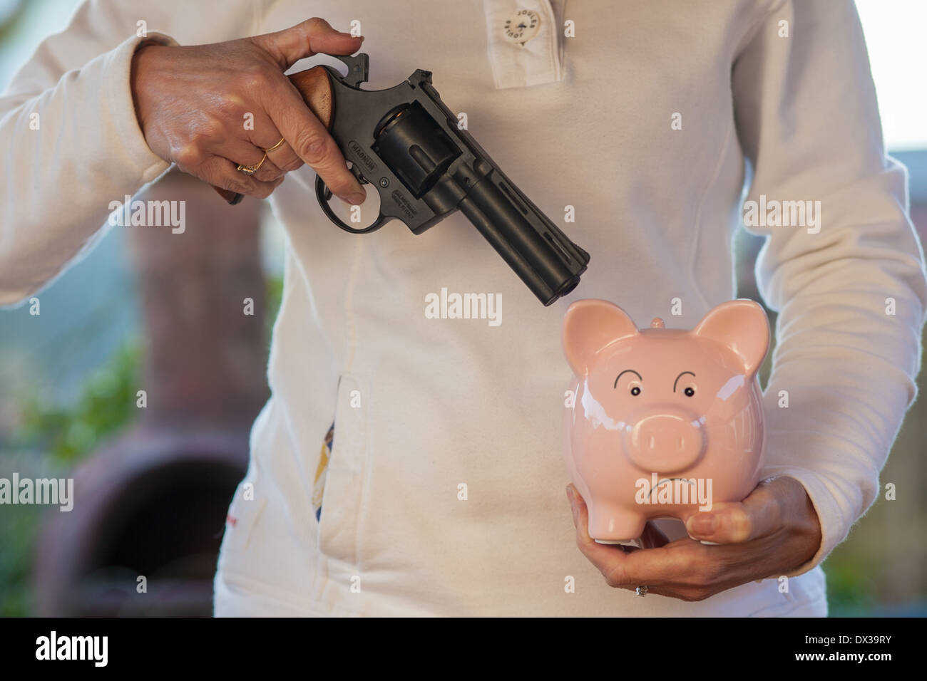 China pink piggy bank being threatened with a gun Stock Photo - Alamy