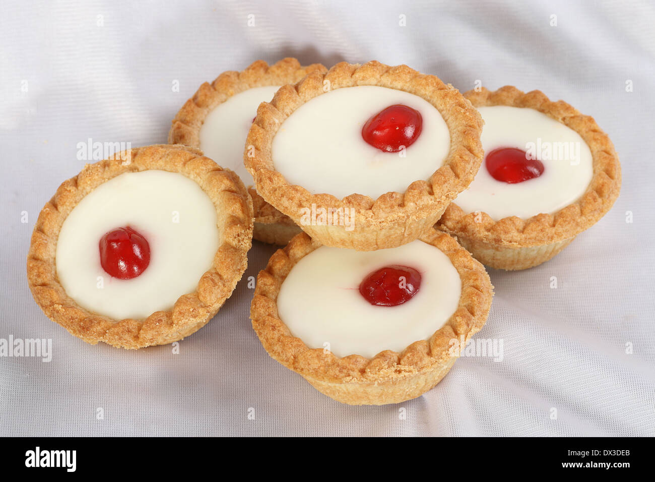 five cherry bakewell cakes on a white cloth Stock Photo - Alamy